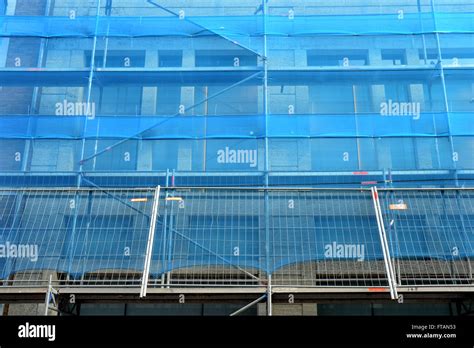 Scaffolding And Blue Canvas Covering In Front Of Building Being