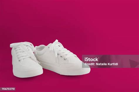 흰색 배경에 고립 된 새로운 흰색 여성 또는 십대 운동화 밝은 회색 배경에 끈이 달린 고무 밑창이 있는 흰색 텍스타일 스니커즈