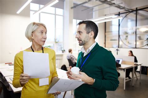 현대 사무실에 서 있는 스웨터의 비즈니스 컨퍼런스 참가자 및 텍스트와 논문을 보면서 프레 젠 테이 션을 논의 경영자에 대한 스톡 사진 및 기타 이미지 Istock