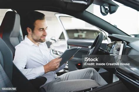 자동차 딜러 상점에서 비싼 자동차를 구입 새로운 자동차에 대한 클립 보드에 독서 정보 옵션을 확인 공식 옷을 성공적인 백인 젊은 사업가 20 24세에 대한 스톡 사진 및