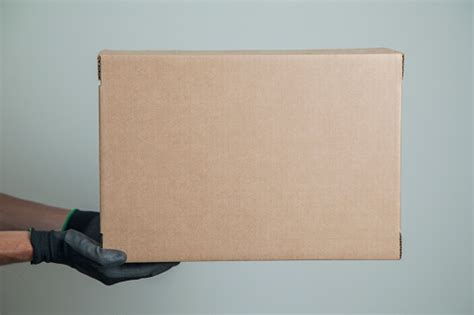 회색 배경에 제품을 제공하기위한 골판지 상자를 들고 검은 장갑을 가진 남자의 세부 사항 Store Opening에 대한 스톡 사진 및 기타 이미지 Store