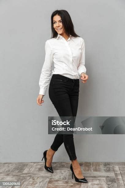흰색 셔츠와 검은 바지를 입고 회색 배경에 고립 된 미소로 옆으로 보이는 행복한 사업가의 전체 길이 이미지 잘 차려입은에 대한 스톡 사진 및 기타 이미지 Istock