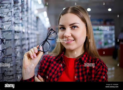 A Visually Impaired Girl Chooses Glasses She Is Wearing A Shirt And A Beautiful Smile Stock