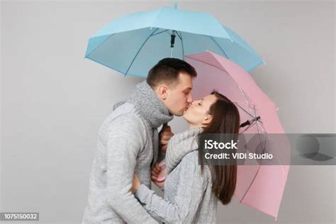 회색 벽 배경 스튜디오 초상화에 고립 된 우산 아래 함께 회색 스웨터 스카프에 커플 여자 사람입니다 건강 한 생활 습관 병 아픈 질병 치료 추운 계절 개념 복사 공간을 모의