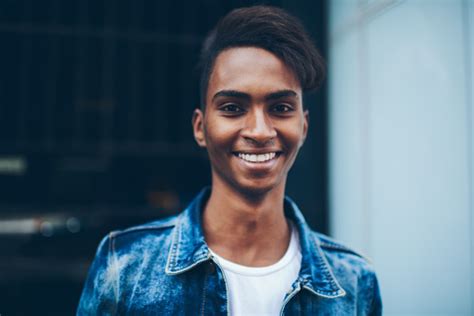 카메라에 미소 명랑 힌두교 젊은 남자의 초상화를 닫습니다 야외서 흰색 치아와 잘 생긴 남성 십대 얼굴 의 긍정적 인 힙스터 학생