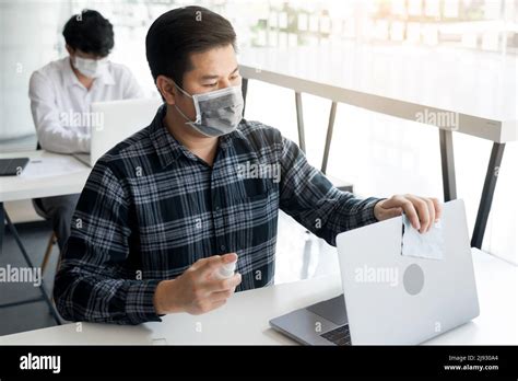 Employees Are Spraying With Alcohol To Wipe Clean Office Equipment