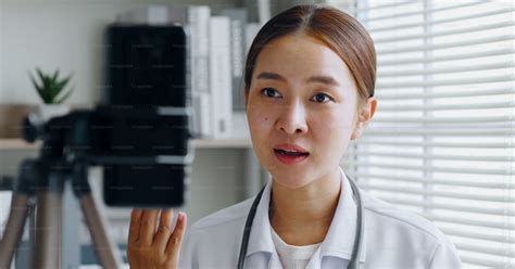 병원에서 카메라 녹화를 통해 이야기하는 온라인 라이브 스트리밍 방송을 만드는 아시아 여성 의사 의료 및 의료 블로거 블로거 개념 사진 Unsplash의 아시아 이미지