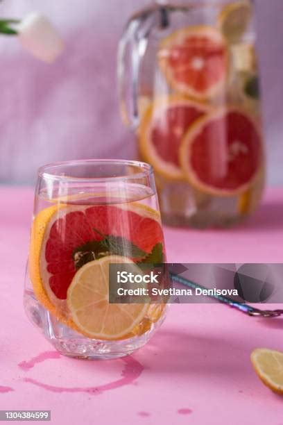 얼음과 감귤류가 들어간 투명한 음료가 있는 유리 근처의 거짓말 슬라이스 자몽과 레몬과 여러 가지 색깔의 숟가락 0명에 대한 스톡 사진 및 기타 이미지 Istock