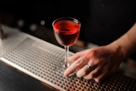 강철 바 카운터의 유리에 투명 한 레드 칵테일을 제공 하는 바텐더 각얼음에 대한 스톡 사진 및 기타 이미지 각얼음 갈색