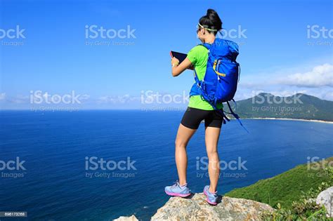 해변 산 바위에 디지털 태블릿을 사용 하는 성공적인 여성 배낭 가장자리에 대한 스톡 사진 및 기타 이미지 가장자리 동기 부여 디지털 태블릿 사용하기 Istock