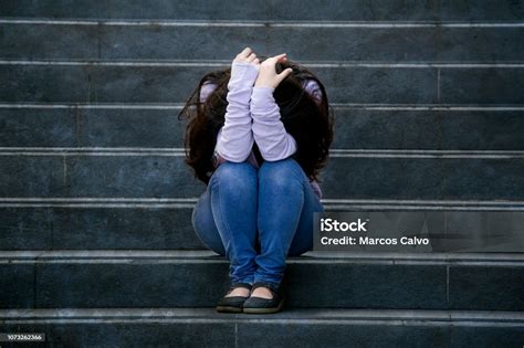 슬 프 고 우울 젊은 학생 여자 또는 왕 따 십 대 소녀 느낌 절망 고통 우울증 문제를 왕 따의 거리 계단 무서 워 하 고 불안 피해자에 야외에서 앉아 아이에 대한 스톡