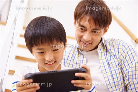 一緒にゲームをする日本人の親子の写真素材 [200239348] イメージマート