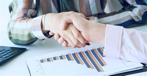 친절 한 사업가 즐거운 이야기와 효과적인 협상 좋은 관계 후 경제 차트와 사무실 책상을 통해 핸드쉐이킹 경영자에 대한 스톡 사진