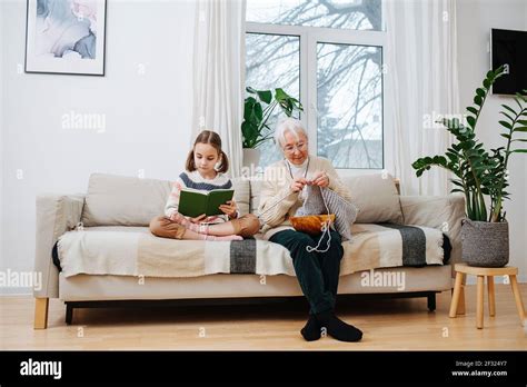 Alte Oma Sitzt Mit Ihrer Enkelin Auf Der Couch Der Eine Liest Und Der