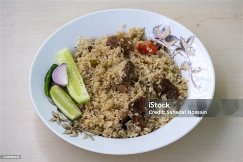 나무 배경에 오이 조각 양파 청양고추를 곁들인 흰색 접시에 맛있는 쇠고기 테하리 쌀과 쇠고기로 만든 방글라데시 전통 요리입니다 건강한 생활방식에 대한 스톡 사진 및 기타