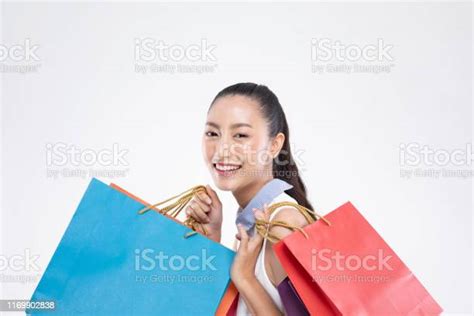 아름다운 매력적인 아시아 여자 미소와 쇼핑 백을 들고 너무 행복느낌과 쇼핑몰에서 검은 금요일 판매와 함께 즐길 수 흰색 배경에 고립 쇼핑 개념 가방에 대한 스톡 사진 및