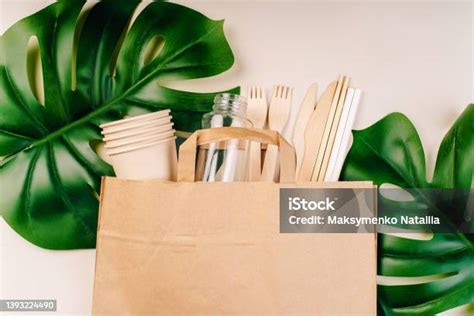 에코 공예 종이 식기 컵 패스트 푸드 용기 재활용 환경 친화적 인 개념 일회용 에코 칼 붙이 접시 숟가락 나이프 가벼운 배경에 포크 음식 배달을위한 종이 봉지를 제작하십시오