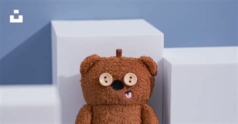 흰색 블록 위에 앉아 있는 갈색 곰 인형 사진 Unsplash의 무료 장난감 이미지