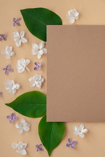 빈 봉투와 베이지색 배경에 아름다운 봄 라일락 꽃이 있는 구성 모형 카드 초대장 인사말 카드 엽서 복사 공간 템플릿입니다 라일락