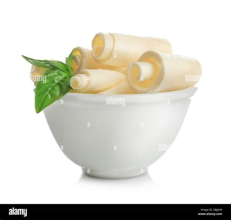Bowl With Delicious Butter Curls And Basil On White Background Stock