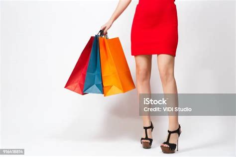 슬림 블랙 샌들에 긴 여성 다리 빨간색에서 백인 여자 들고 3 멀티 흰색 배경에 고립 쇼핑 후 패킷을 구매와 컬러 드레스 광고에 대 한 공간을 복사 합니다 가방에 대한 스톡