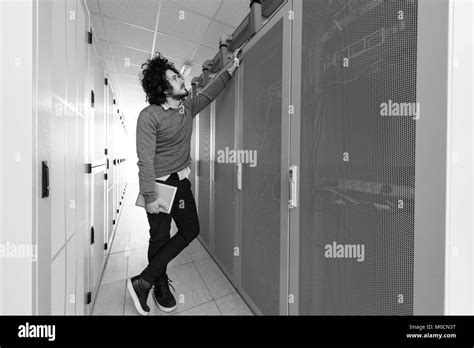 Male It Engineer Working On A Tablet Computer In Server Room At Modern