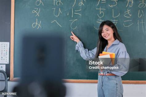 영어 교실에서 학생을 가르치는 웃는 아시아 교사 여성 칠판에 글을 쓰는 여성 교사 고등학교 및 학교 개념으로 돌아 가기 교사