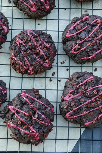 분홍색 물 장식 와이어 냉각 그리스 방지 종이 양피지 위의 금속 랙 높은 보기로 장식 된 갓 구운 수제 초콜릿 칩 블랙 포레스트 쿠키의 행의 클로즈업 이미지 0명에 대한