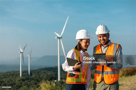 풍차 농장에서 일하는 두 명의 엔지니어 남자와 여자가 전기 청정 에너지를 생성합니다 대체 녹색 에너지에 의한 풍력 터빈 농장