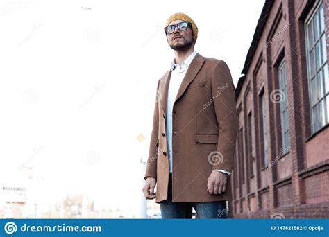 Portrait Of Stylish Handsome Young Man In Glasses With Bristle Standing