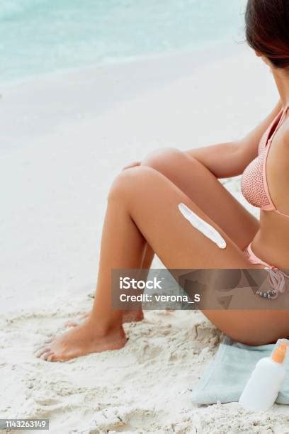 여성은 부드러운 무두 질 다리에 자외선 차단 크림을 바릅니다 스킨케어 근접 촬영에 여성 손 얼룩 보습로 태양 블록 개념입니다