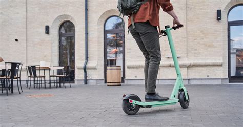 봄의 따뜻한 날에 도시 거리에서 전동 스쿠터를 타는 쾌활한 활동적인 남자의 잘린 모습 교통 및 사람 개념 사진 Unsplash의 자유 이미지