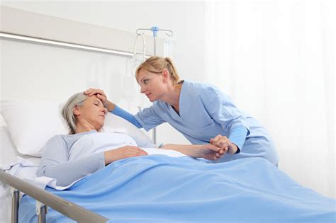 간호사는 병원 방 침대에 누워 있는 안락한 노인 여성을 데리고 그녀를 쓰다듬고 물방울 바늘이 있는 팔을 잡고 외로움과 노령질병의 개념 2명에 대한 스톡 사진 및 기타 이미지