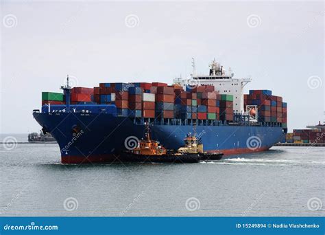 Container Vessel Berthing At An Industrial Port Tugboat Push Large Cargo Vessel To Berth At