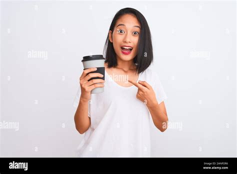 Young Chinese Woman Drinking Take Away Glass Of Coffee Over Isolated