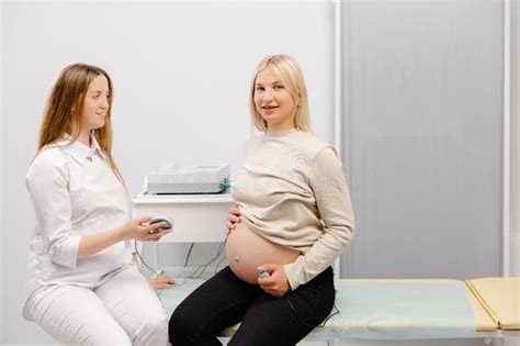 Woman Pregnant Checking Fetal Heart Beat By Fetal Monitoring Expectant Mother With Midwife