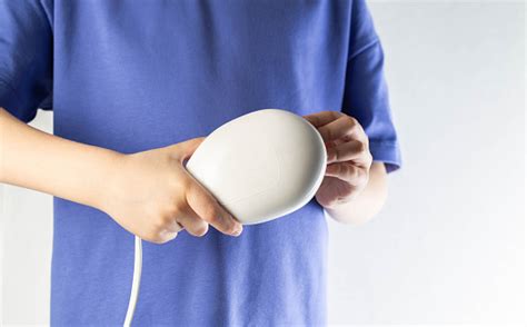 한 아이가 질병의 복원 및 치료를 위한 저주파 휴대용 자기 치료 장치를 손에 들고 있습니다 가정 물리 치료 재활 텍스트 공간