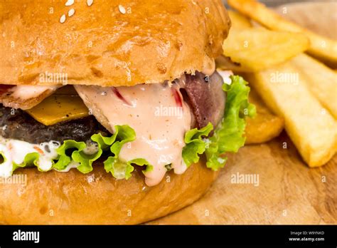 Hamburger With Pork Beef And Vegetables Is In The Bread Overlapping