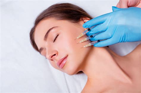 아름다움 주입입니다 여성 얼굴 근처 주사기와 의사의의 근접 촬영 얼굴 피부 리프팅 치료를 받고 하는 아름 다운 여자의 초상화 건강관리와 의술에 대한 스톡 사진 및 기타