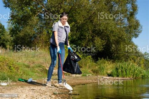 자원 봉사 여성은 강 의 해안에 플라스틱 쓰레기를 따기 청소 환경 개념 쓰레기에 대한 스톡 사진 및 기타 이미지 쓰레기 집어들기 25 29세 Istock