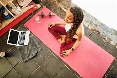 노트북에서 라이브 스트리밍 요가 수업 중 차고에서 명상하는 여성 땋은 머리에 대한 스톡 사진 및 기타 이미지 땋은 머리