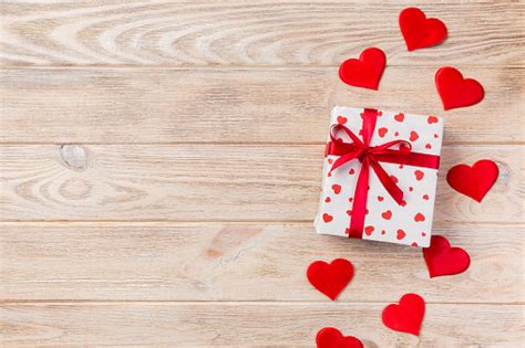 발렌타인 데이 또는 다른 휴일 수 제 종이에으로 현재 휴가 래퍼에 빨간 하트와 선물 상자 디자인을 위한 오렌지 나무 테이블 복사 공간 평면도 빈 공간에 선물 상자를 제시