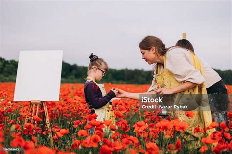 미술 치료사는 양귀비 밭에서 미술 치료를 시작하기 전에 다운 증후군을 앓고있는 소녀에게 붓을 준다 다운 증후군에 대한 스톡 사진 및 기타 이미지 Istock