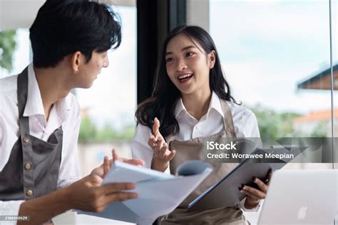 혁신적인 스타트업 사업 계획을 위해 노트북과 문서를 사용하여 현대적인 사무실 환경에서 협업하는 젊은 기업가 2명에 대한 스톡 사진 및 기타 이미지 Istock