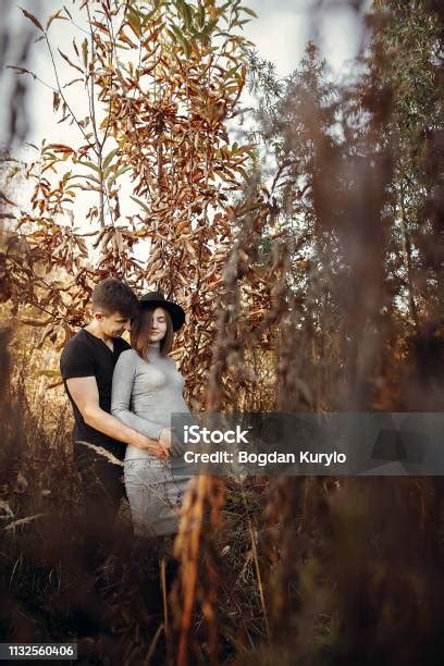 세련 된 임신한 커플가을 공원에서 화창한 빛에 배를 잡고 손을 들고 행복 한 젊은 부모 엄마와 아빠 아기 범프를 포옹 미소 일몰에 아름 다운 순간을 즐기고 부모의 개념