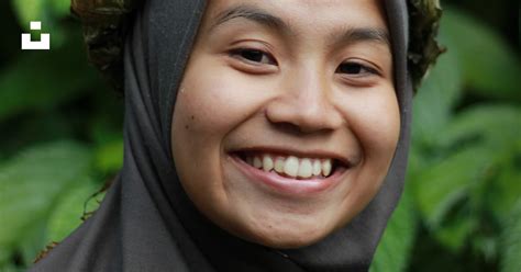 머리 스카프를 두른 여자가 카메라를 향해 미소를 짓고 있다 사진 Unsplash의 무료 베낭 스토켈benang Stokel과 베낭 켈람부 폭포benang