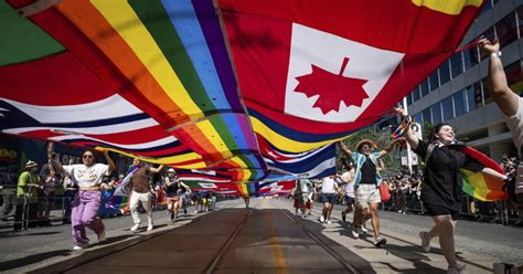 대형 깃발 들고 행진하는 캐나다 프라이드 참가자들
