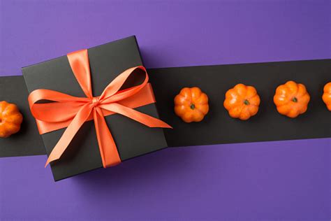 고립 된 백과 카피 스페이스와 보라색 배경에 연속으로 오렌지 리본 활과 작은 호박 할로윈 구성 블랙 기프트 박스의 상단 보기 사진 가을에 대한 스톡 사진 및 기타 이미지