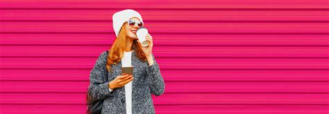 흰색 니트 모자 분홍색 배경에 회색 코트 재킷을 착용 한 스마트 폰으로 세련된 미소 짓는 여성의 초상화 20 29세에 대한 스톡 사진 및 기타 이미지 Istock