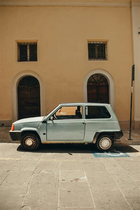 건물 앞에 주차된 작은 파란색 차 사진 Unsplash의 무료 이탈리아 이미지